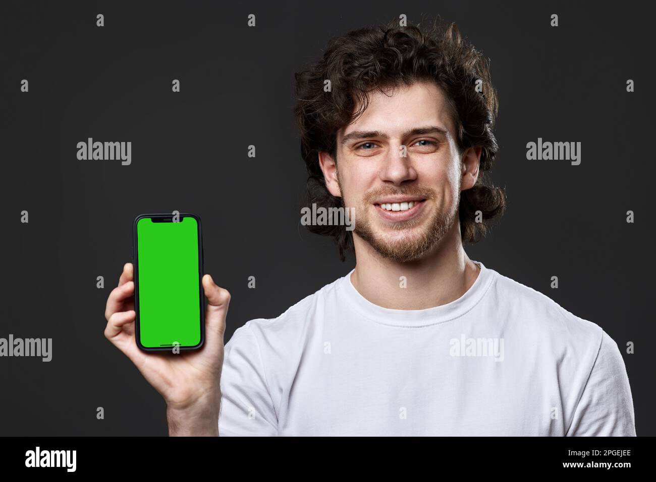 happy young man showing phone with green screen Stock Photo - Alamy