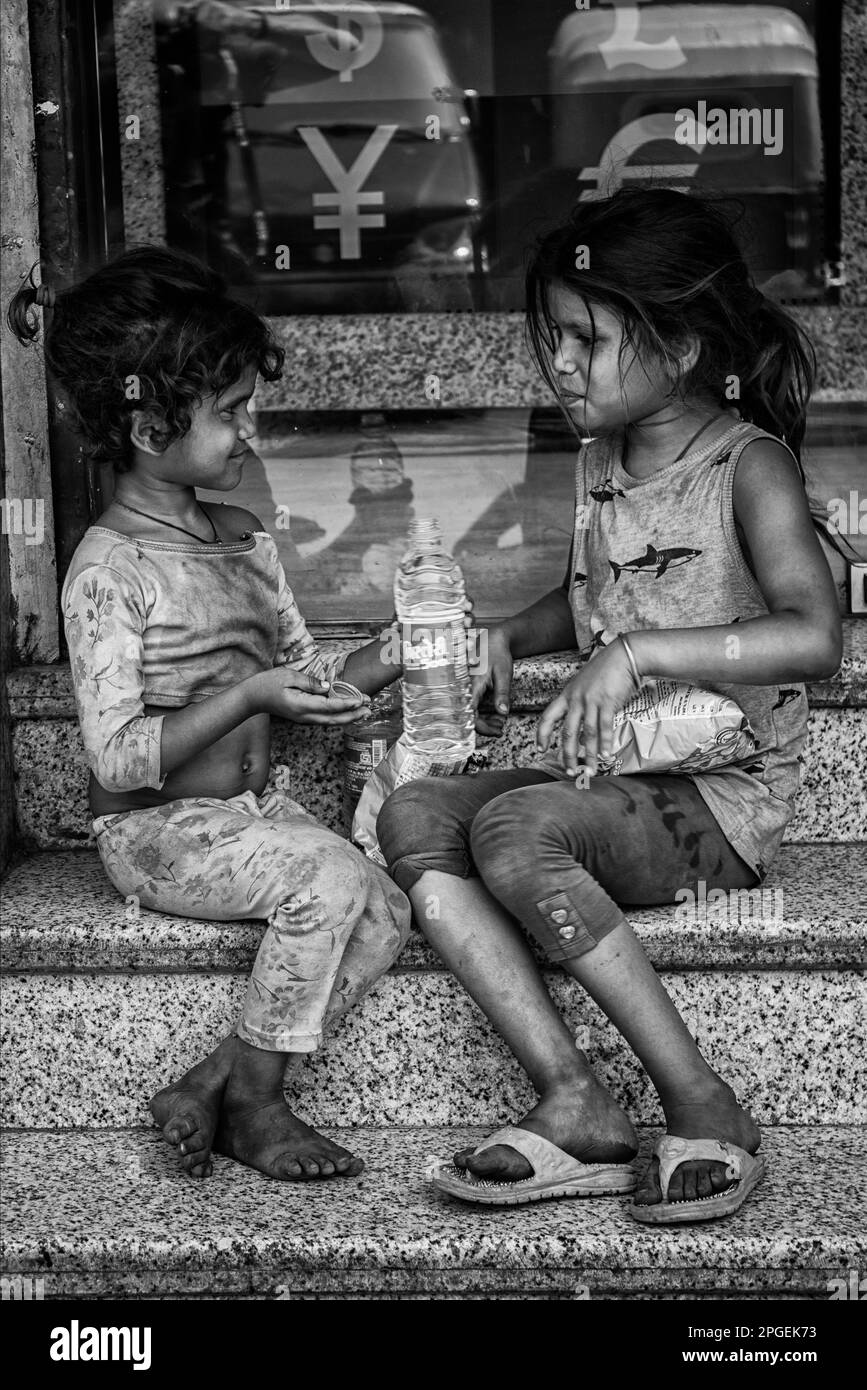 Portrait of two Indian Children eating on the street. Delhi, India ...