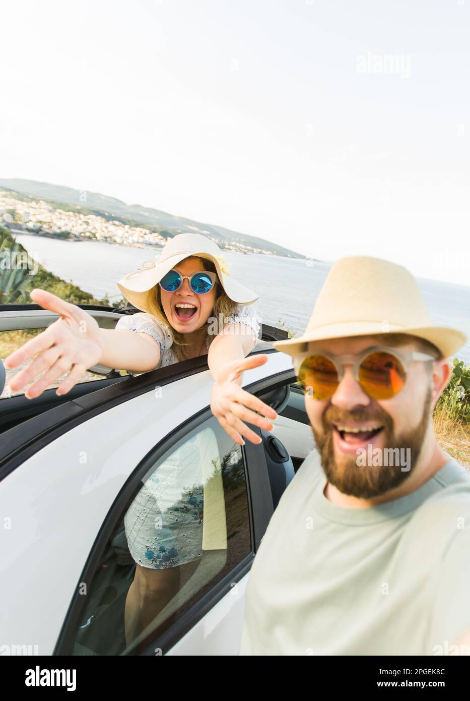 Happy beautiful couple in love taking a selfie portrait driving a ...