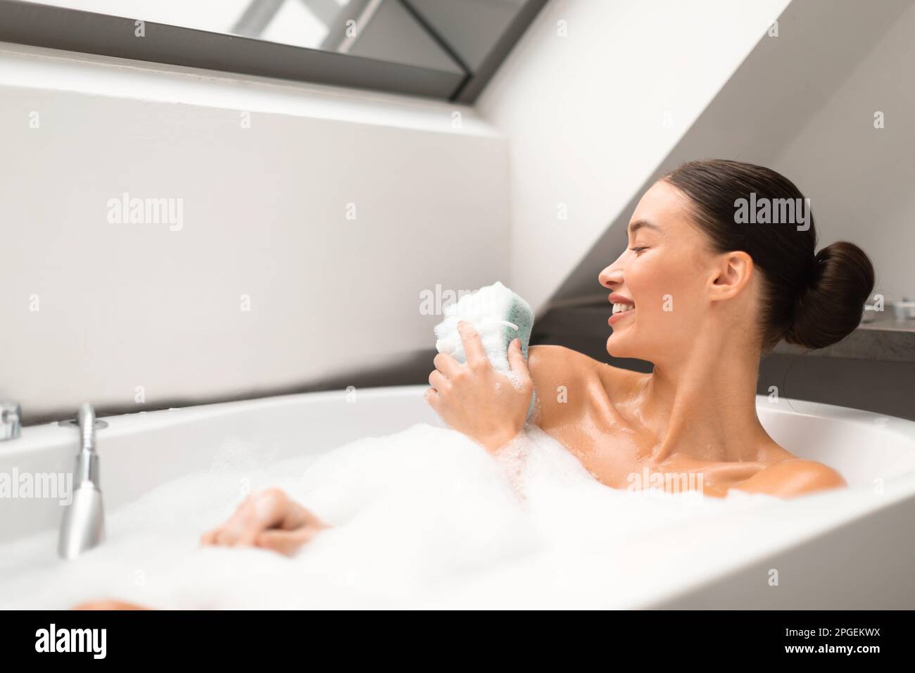 Lady Washing Body With Sponge Taking Bath In Bathroom Stock Photo - Alamy