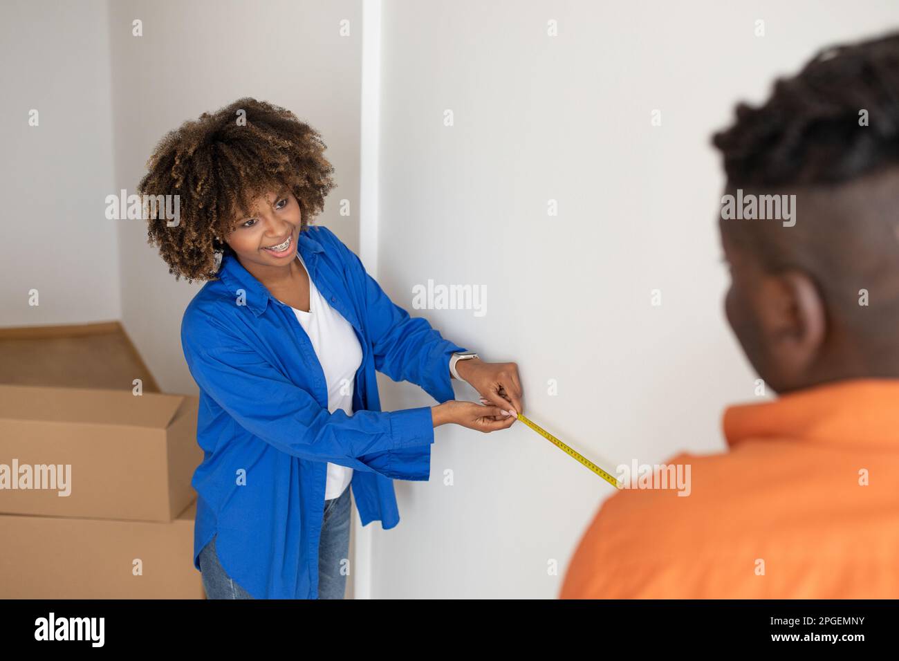 Happy Black Couple Using Tape Ruler Together While Measuring Wall At ...