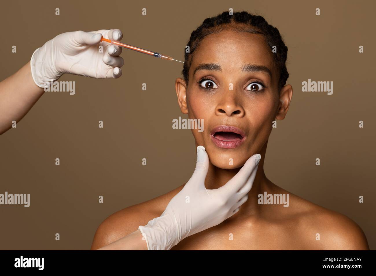 Shocked black middle aged woman receiving beauty shots, using injection ...