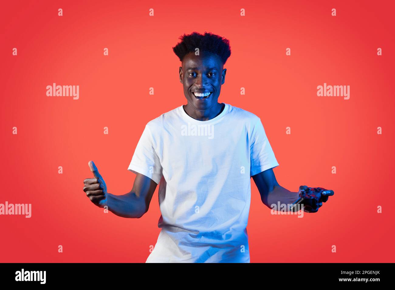 Happy black guy winner holding joystic, showing thumb up Stock Photo ...