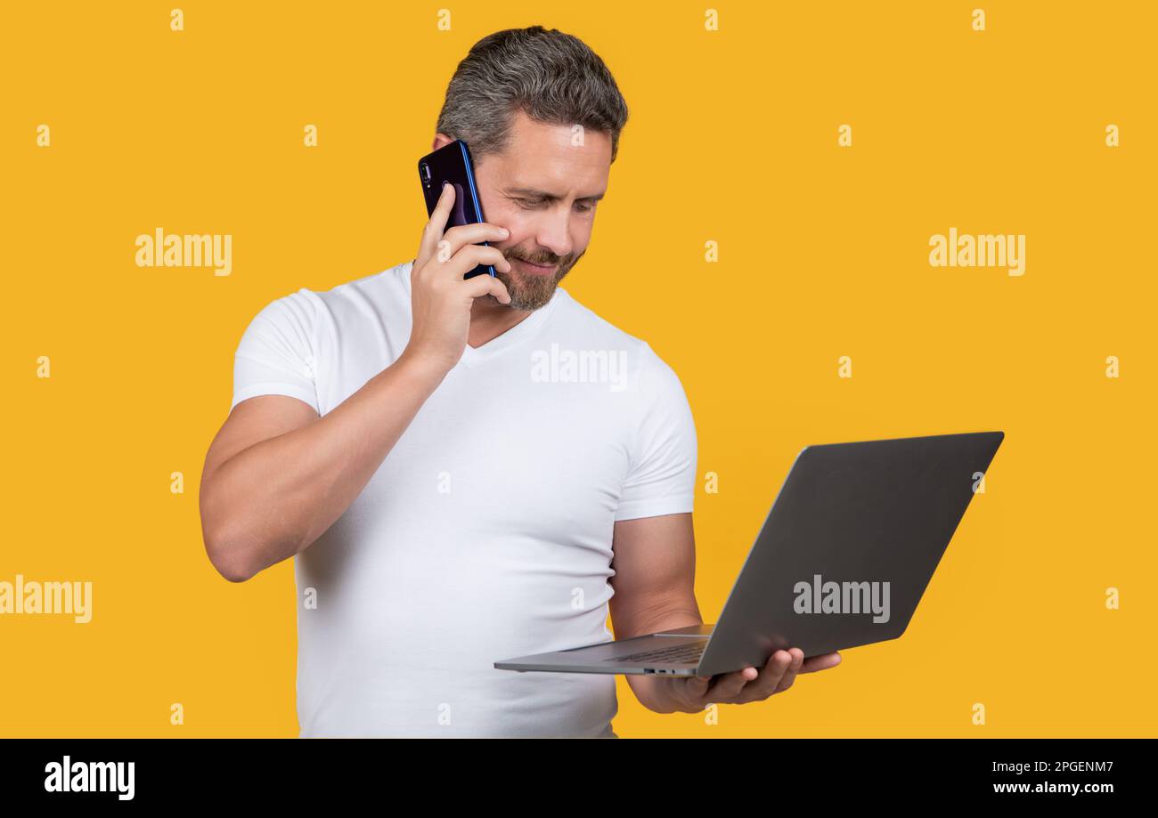 multitasking man freelancing on laptop talking on phone. multitasking man freelancing in studio ...