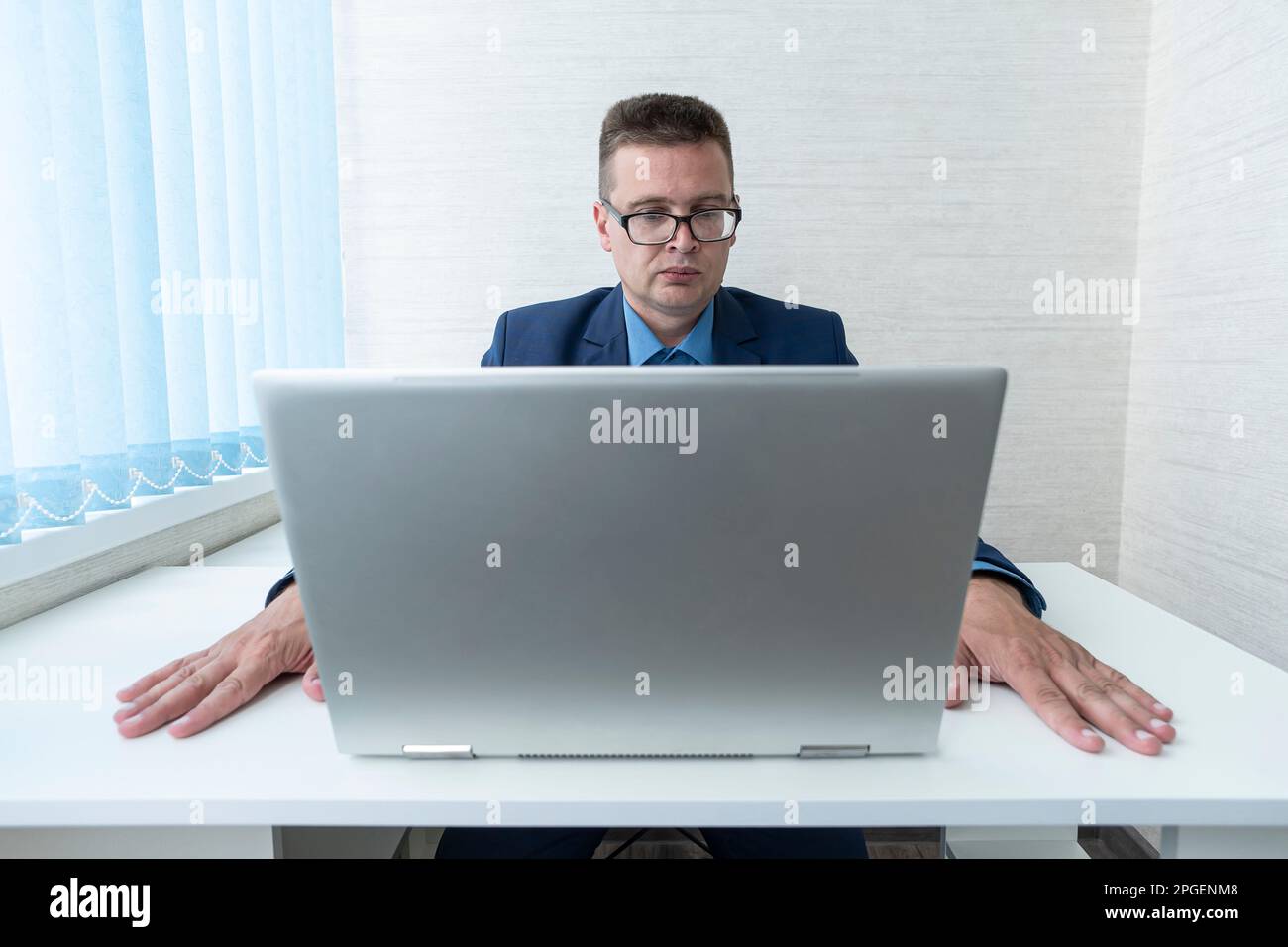 Young employee wearing glasses looking at computer monitor during ...