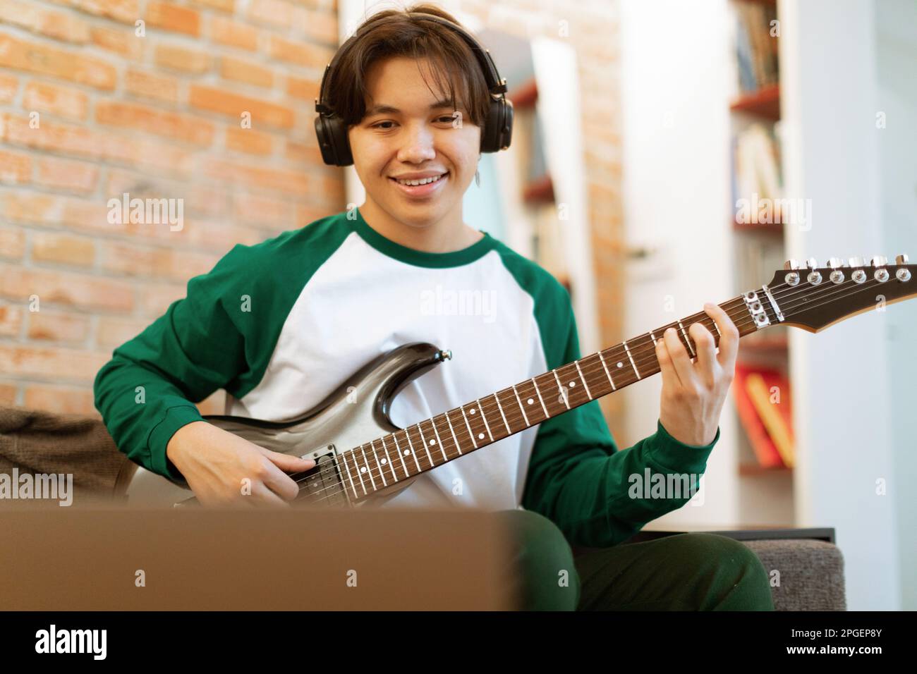 Korean Boy Playing Electric Guitar Near Laptop Sitting At Home Stock ...