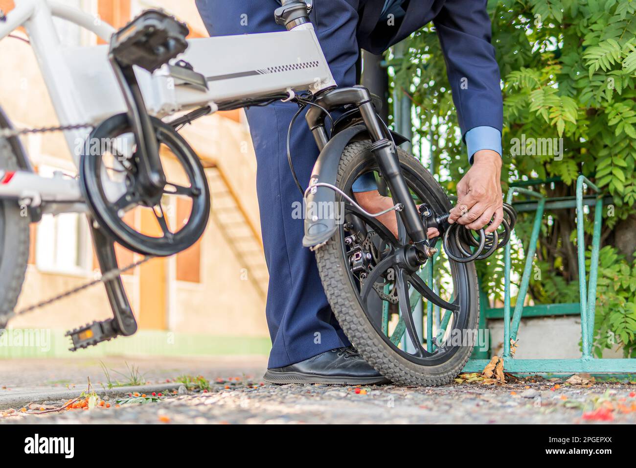 image of the hand locking the bicycle lock. An employee in a suit or a ...