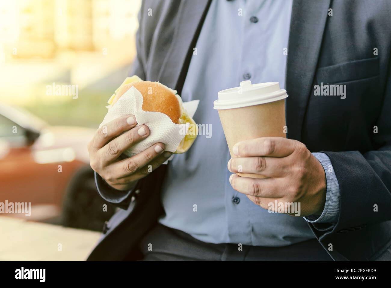 Business man having a breakfast. fast food, junk food in the hand of a ...