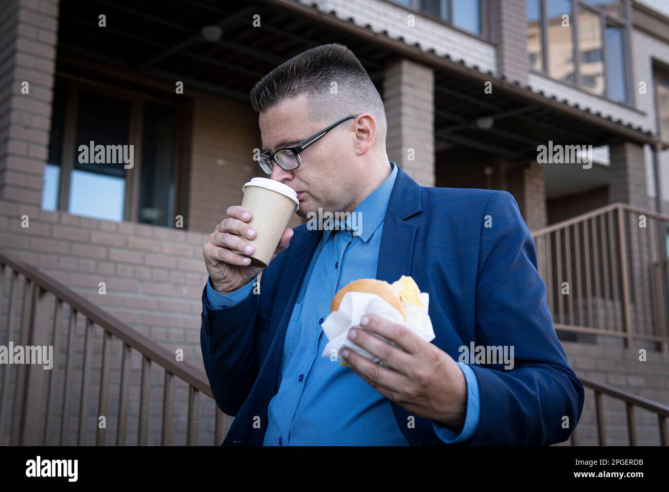 The concept of junk food on the lunch break. Businessman eats unhealthy ...