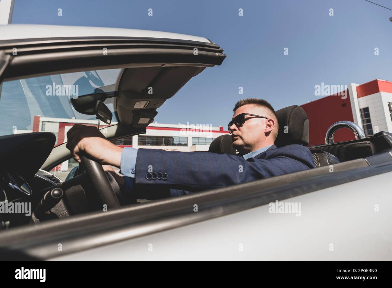 Stylish man sitting in sport car. A successful businessman rides an ...
