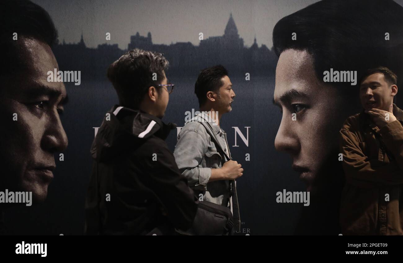 Men standing against a movie poster of 'Hidden Blade' at Filmart held ...