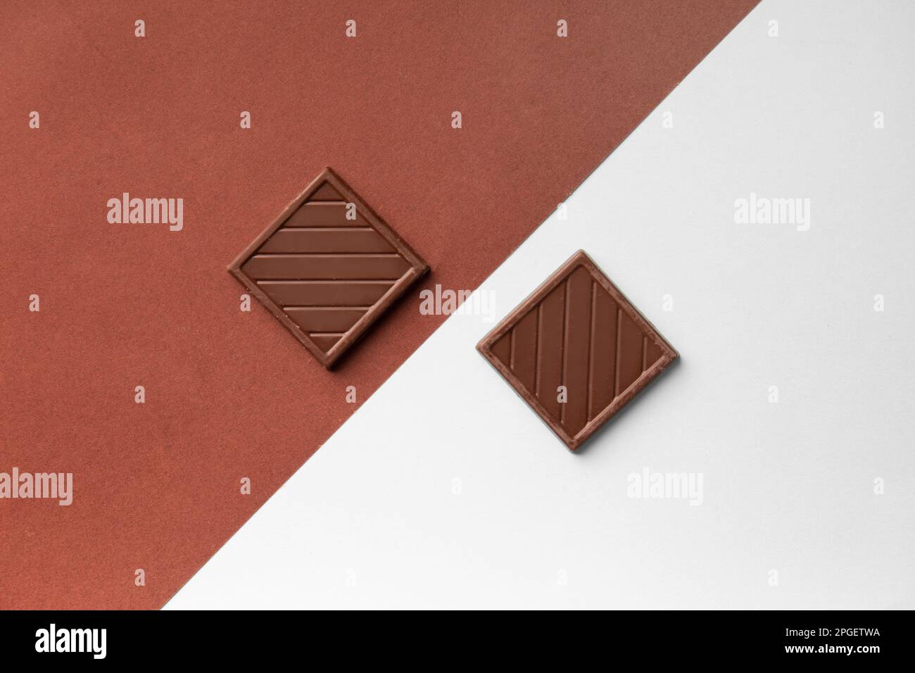 Two chocolate bars on colored backgrounds top view. Small chocolate ...
