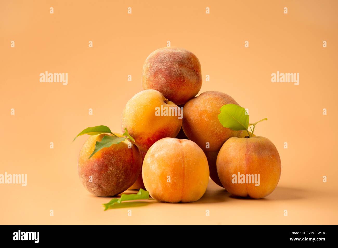 A pile of fresh peaches on a brown background. A handful of raw peaches ...