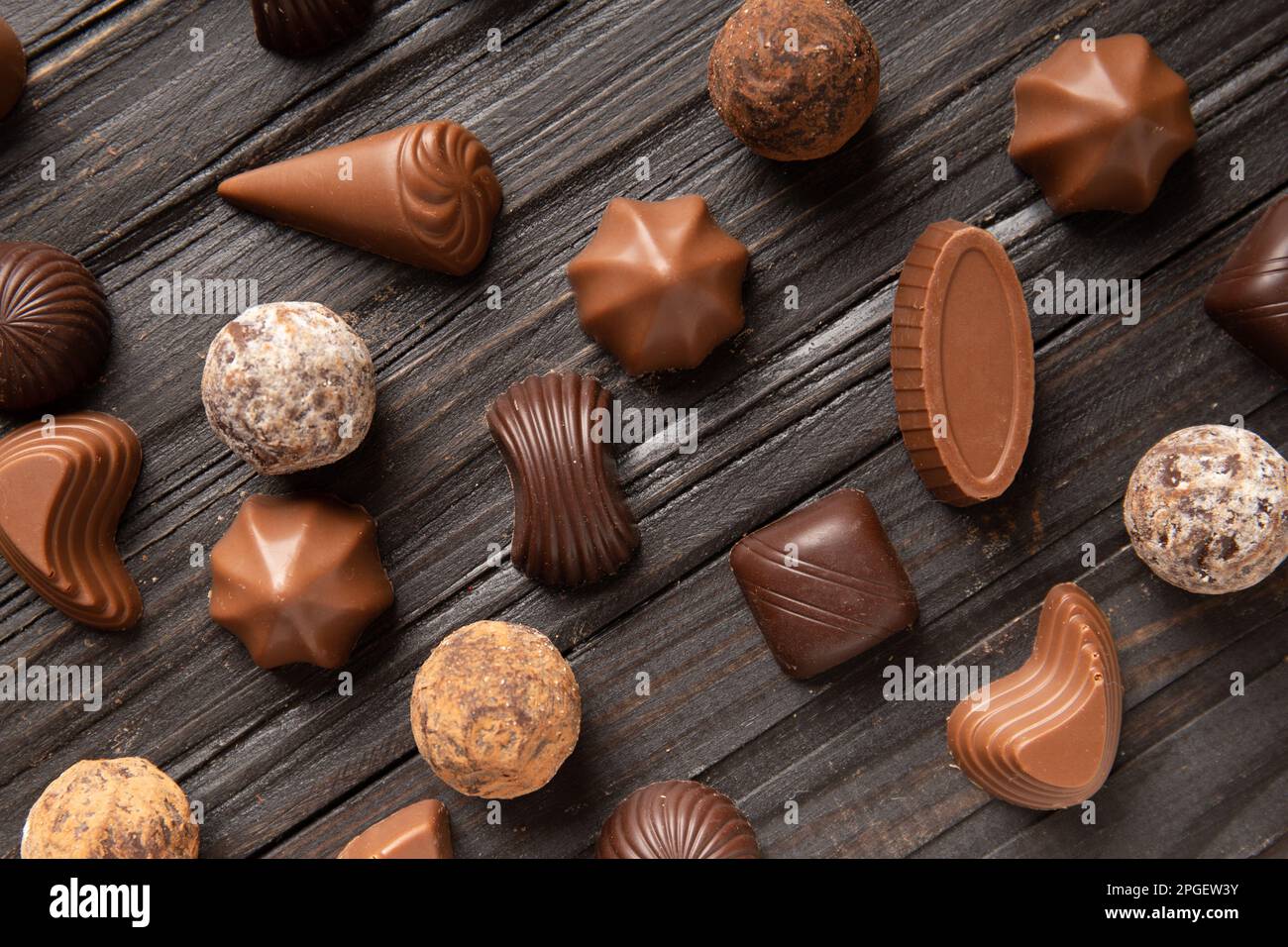 Different chocolate candies on a dark wooden texture background top ...