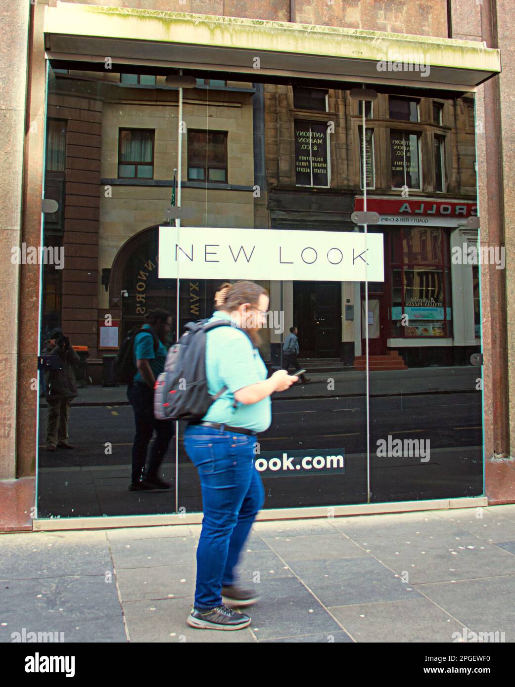 man ising app on smartphone under new look sign Stock Photo - Alamy