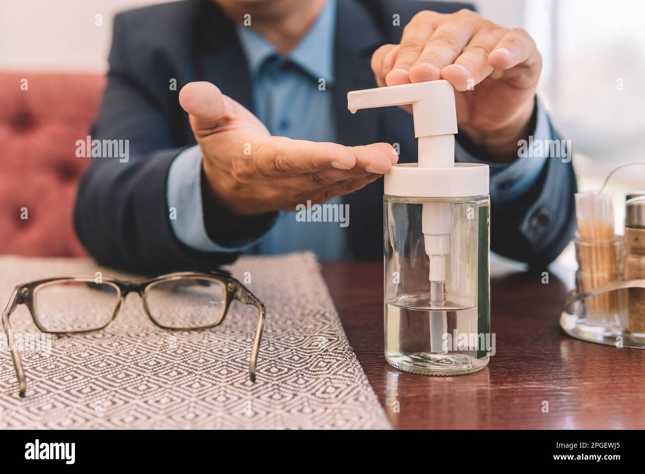 A businessman cleans his hands of bacteria and germs using a table ...