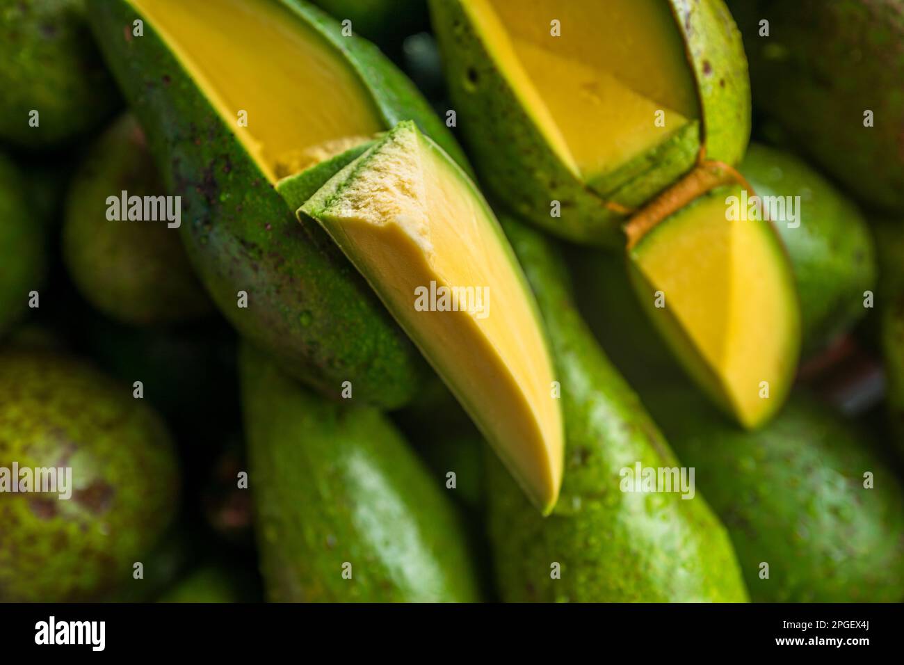 Fresh and ripe avocados, with pieces of flesh cut out to show the ...