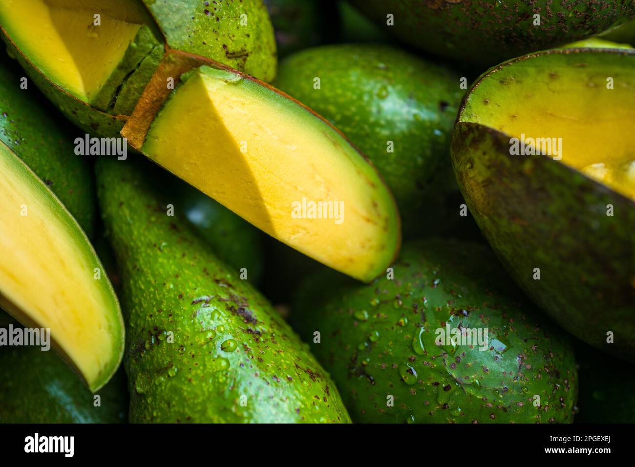 Fresh and ripe avocados, with pieces of flesh cut out to show the ...