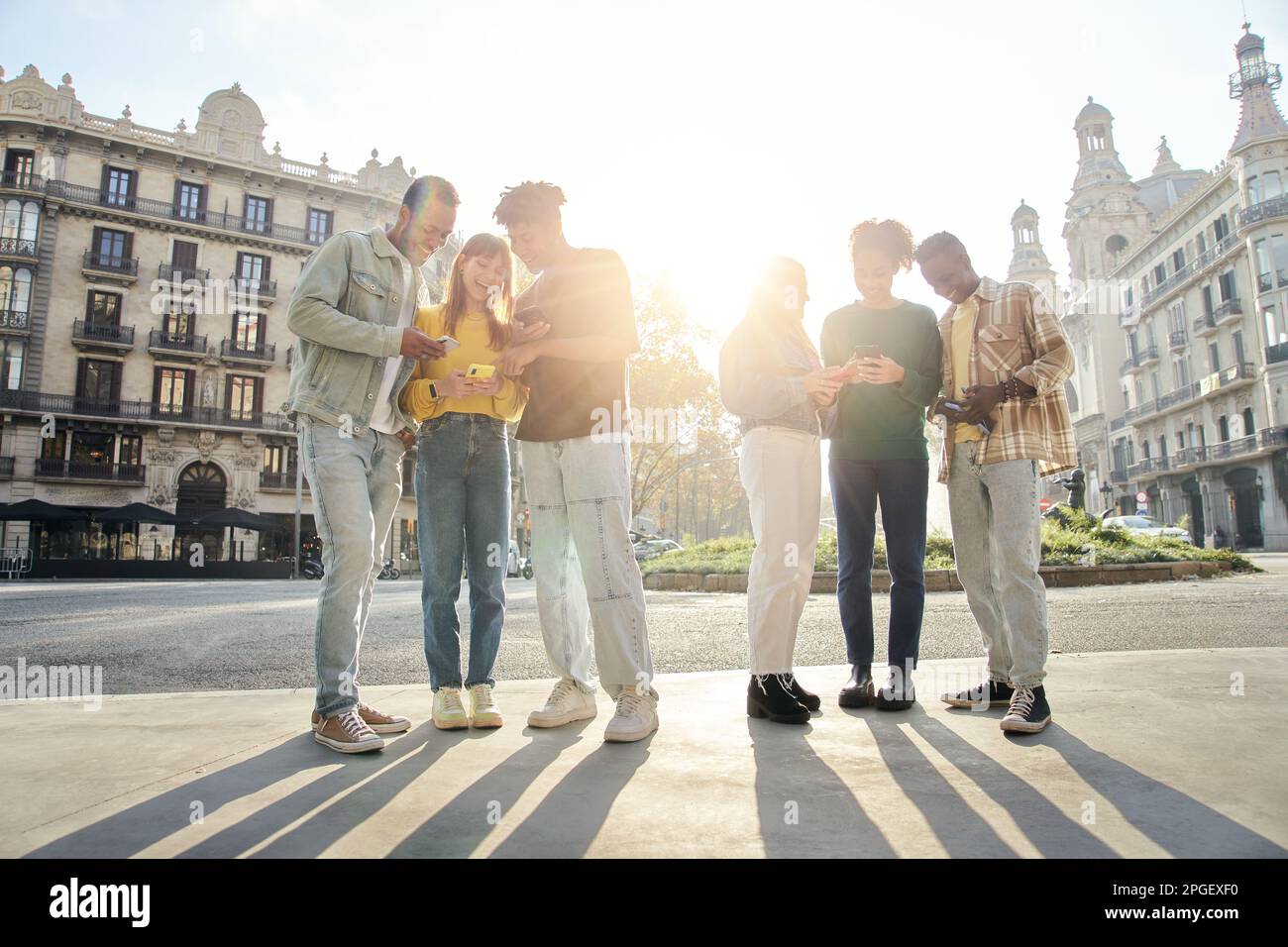 Group smiling multiracial young people using cell phones. Happy ...