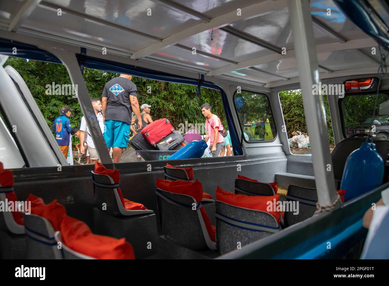La Pavona, Costa Rica - Workers load tourists' luggage on boats on the ...