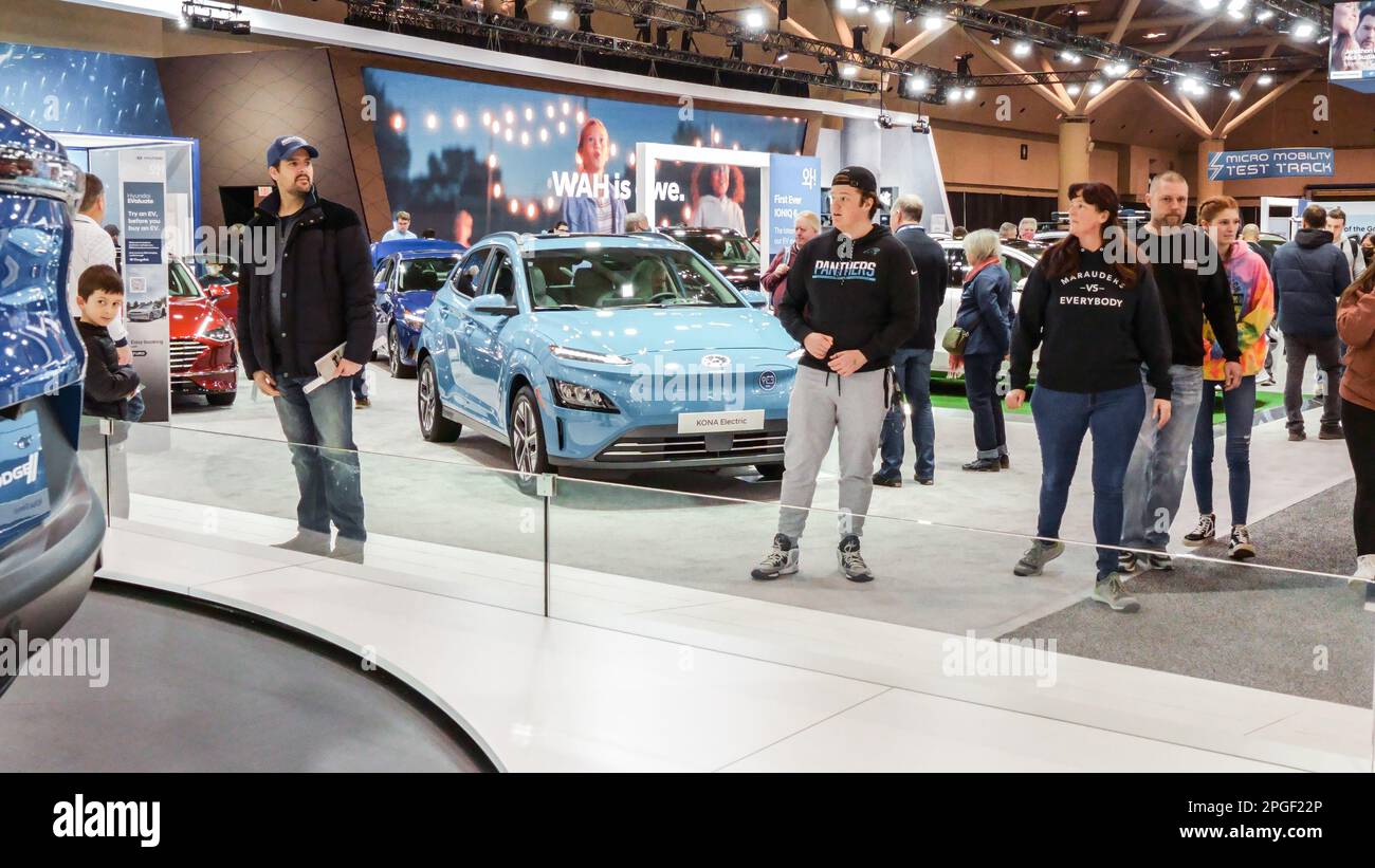 Crowds looking at new car models at Auto show. Hyundai Kona electric ...