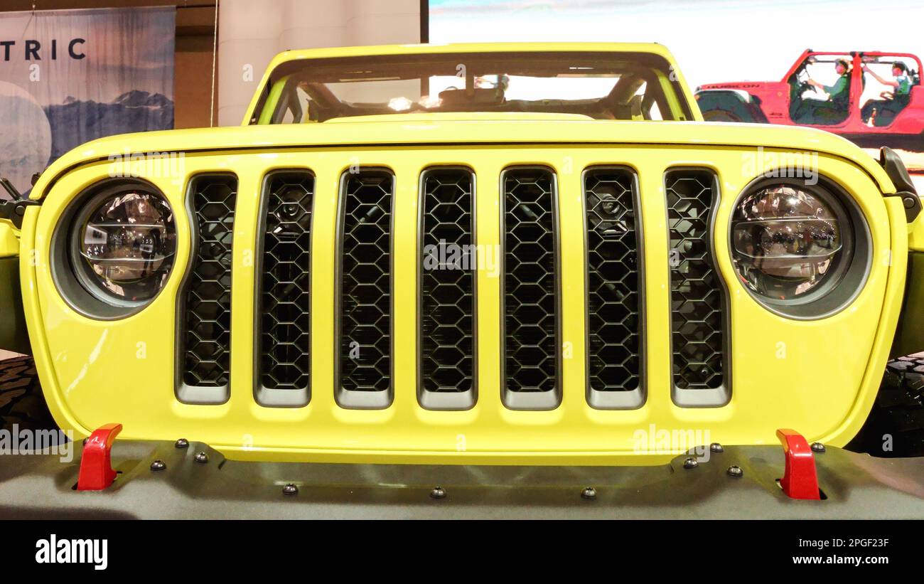 Close up view of yellow Rubicon Jeep car on display. Crowds looking at ...