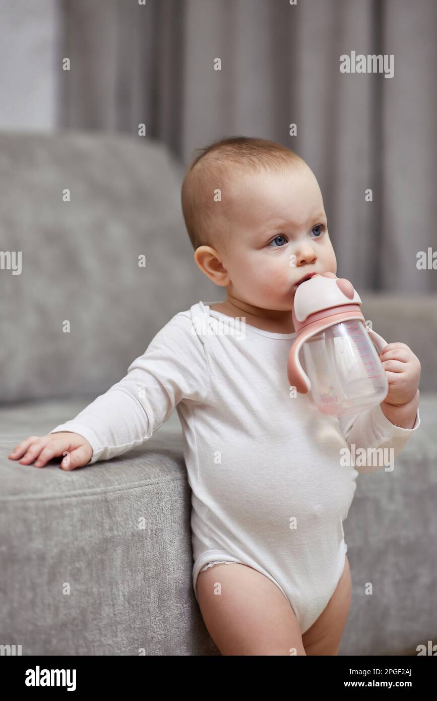 cute baby girl holding bottle and drinking water Stock Photo - Alamy
