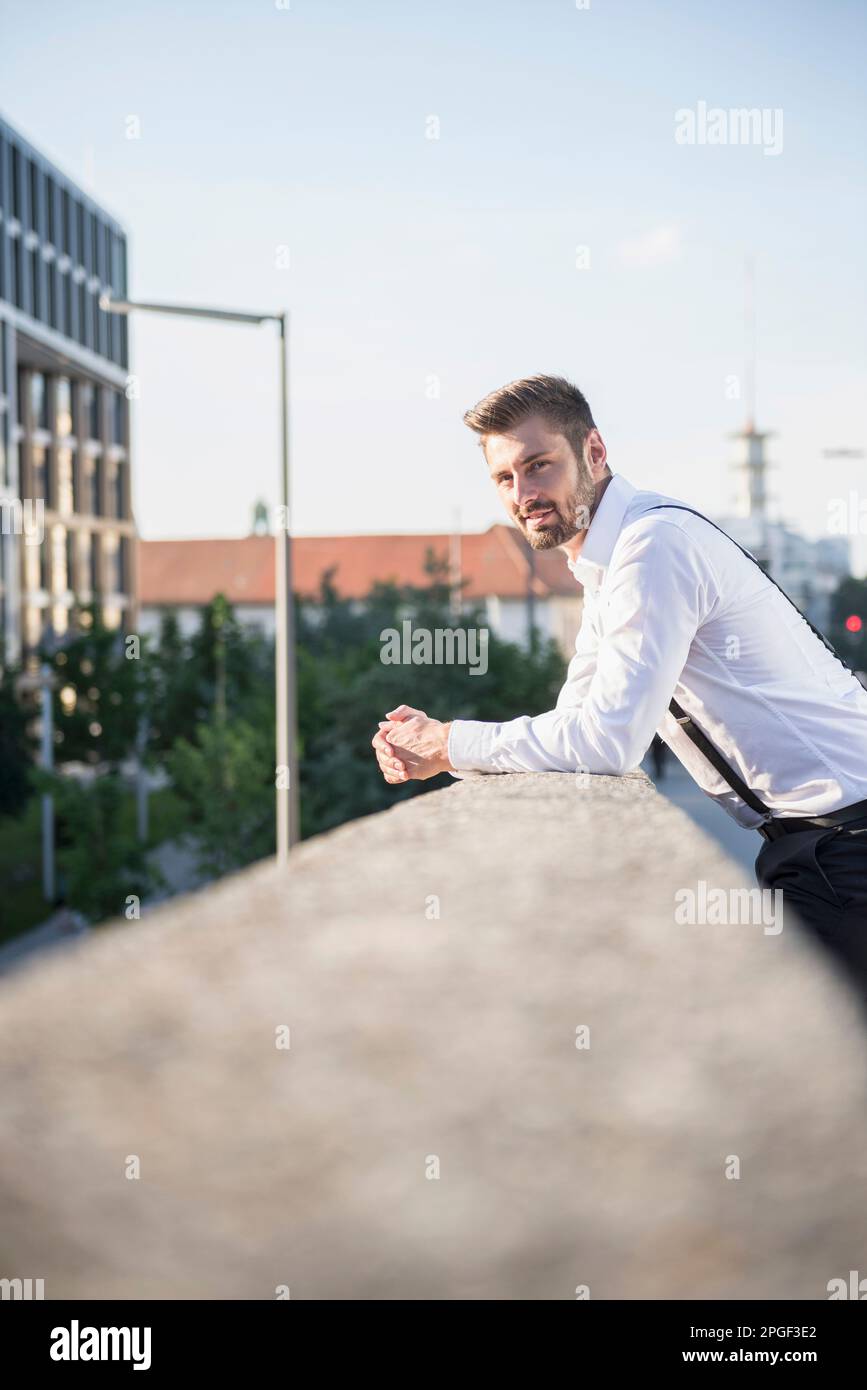 Portrait of a businessman leaning against railing, Munich, Bavaria ...