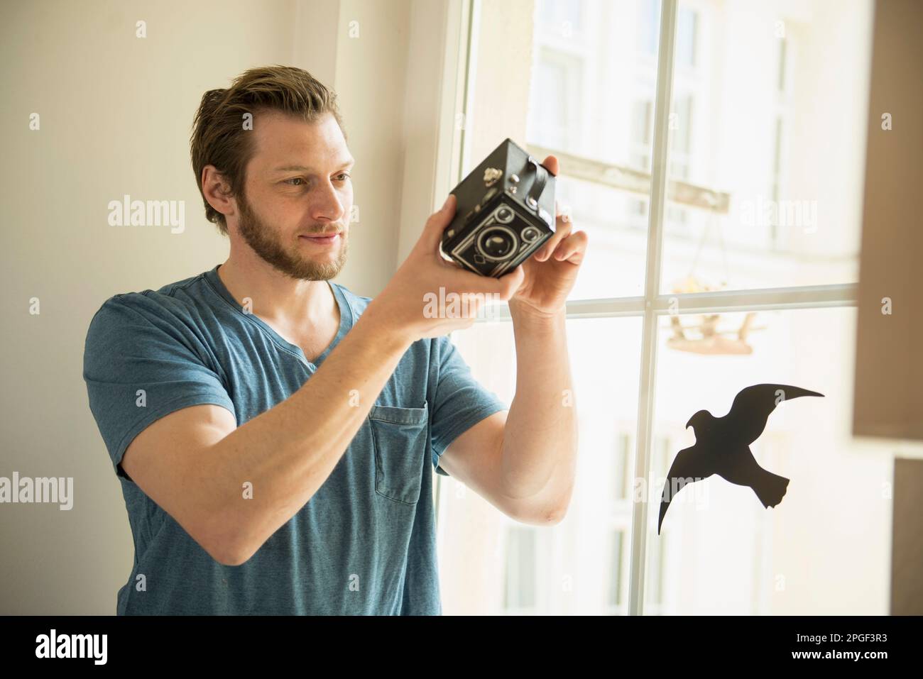 Man examining pinhole camera at window, Munich, Bavaria, Germany Stock ...