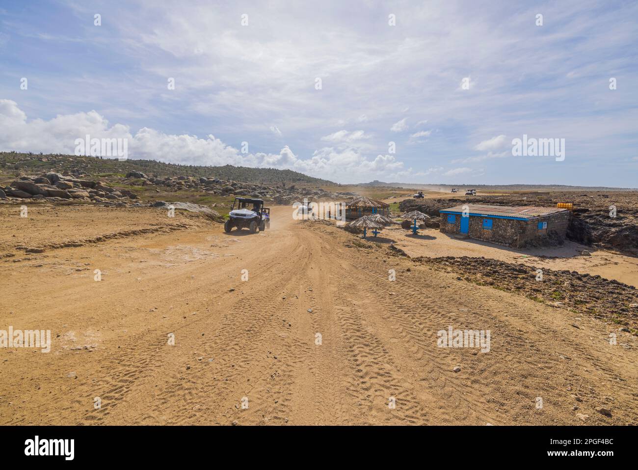 Beautiful view of tourists on off-road cars passing by abandoned house ...