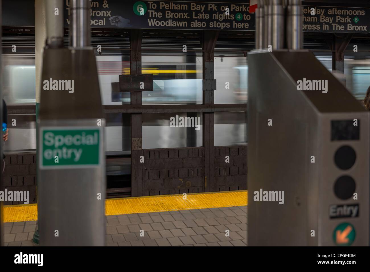 Close-up view out of focus of subway entrance through turnstiles to ...