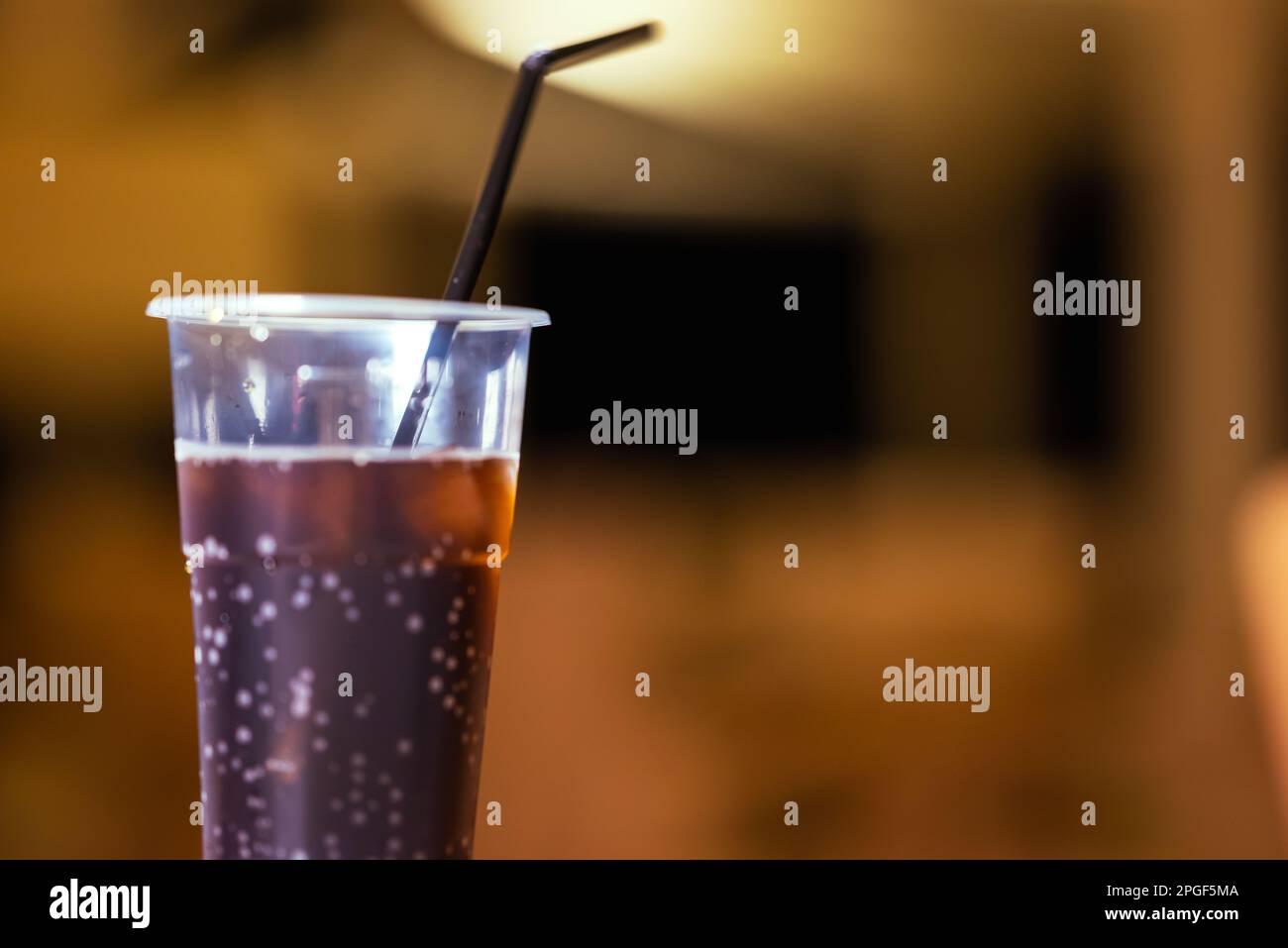 In Foreground In Focus Is Plastic Cup With Dark Cold Drink And Black ...