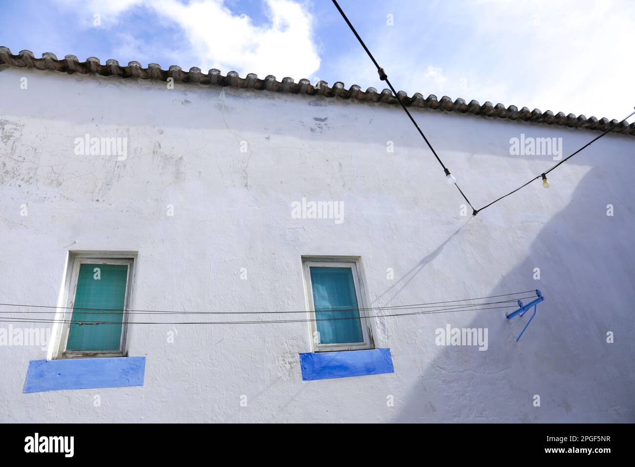 Whitewashed facade in Lisbon with little blue windows Stock Photo - Alamy