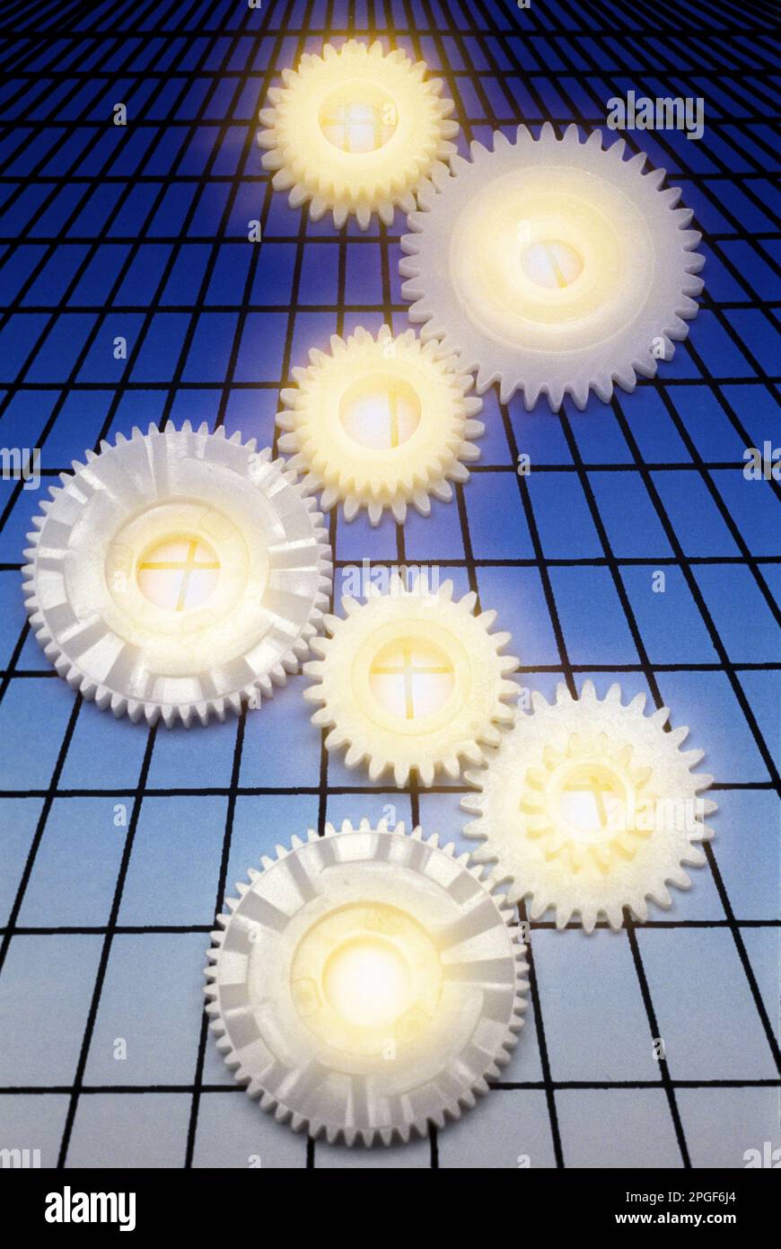 INTERLOCKING COG GEARS WHEELS ON BLUE GRID Stock Photo - Alamy