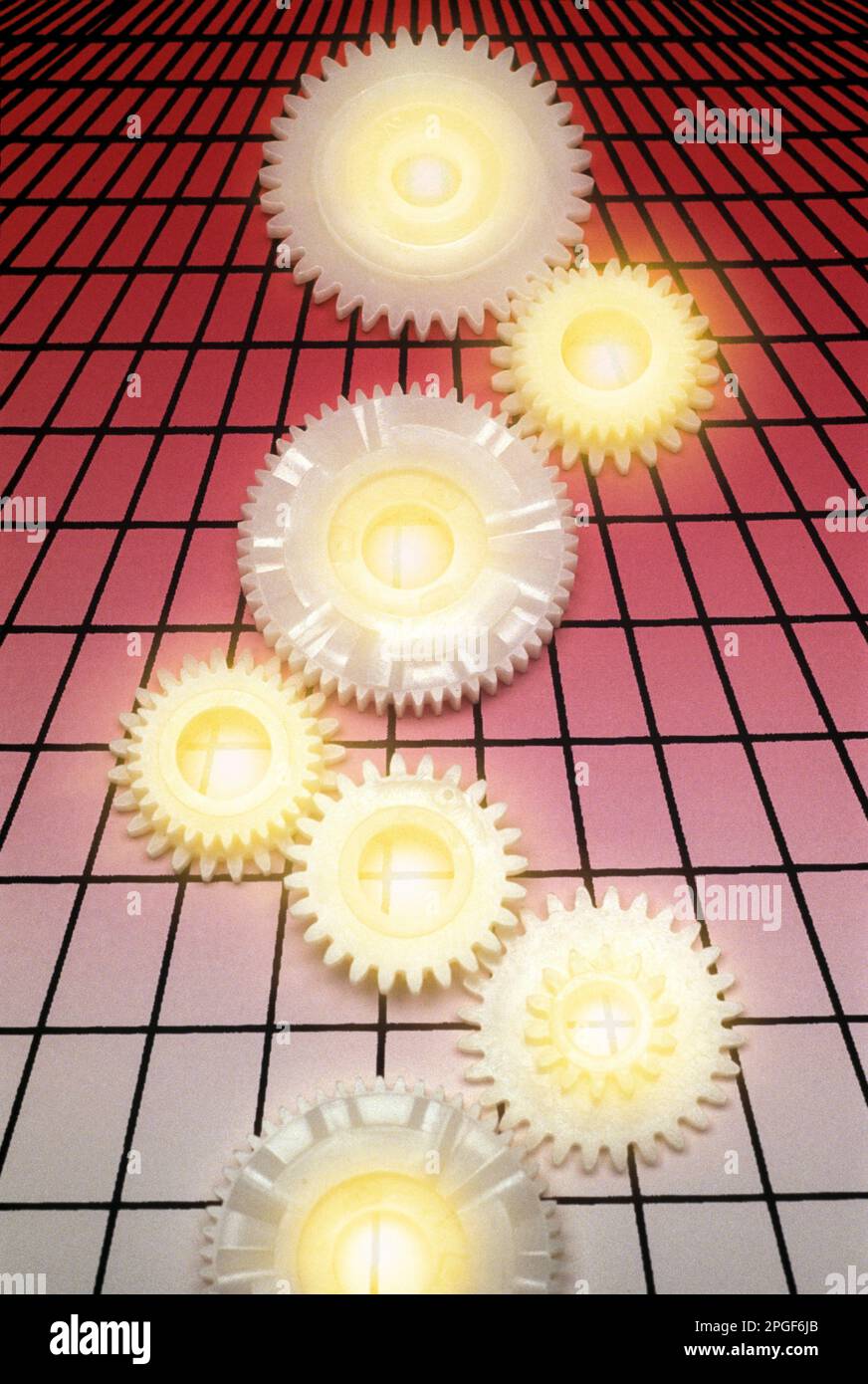INTERLOCKING COG GEARS WHEELS ON RED GRID Stock Photo - Alamy
