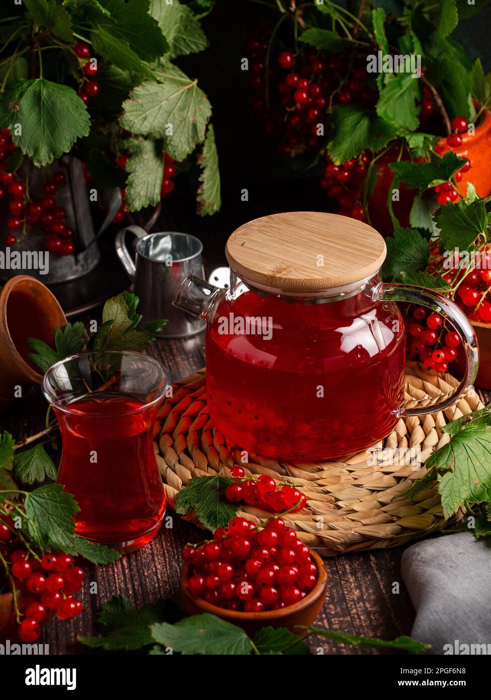 Red currant tea in a glass teapot on a dark background with berr Stock ...