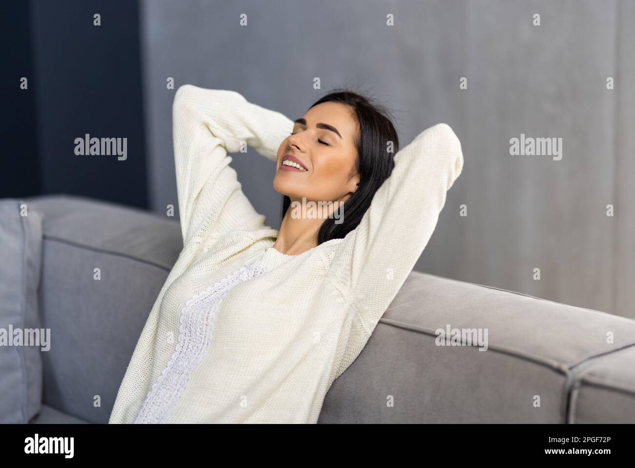 Finally weekends. Millennial girl relaxing at home on couch, enjoying ...