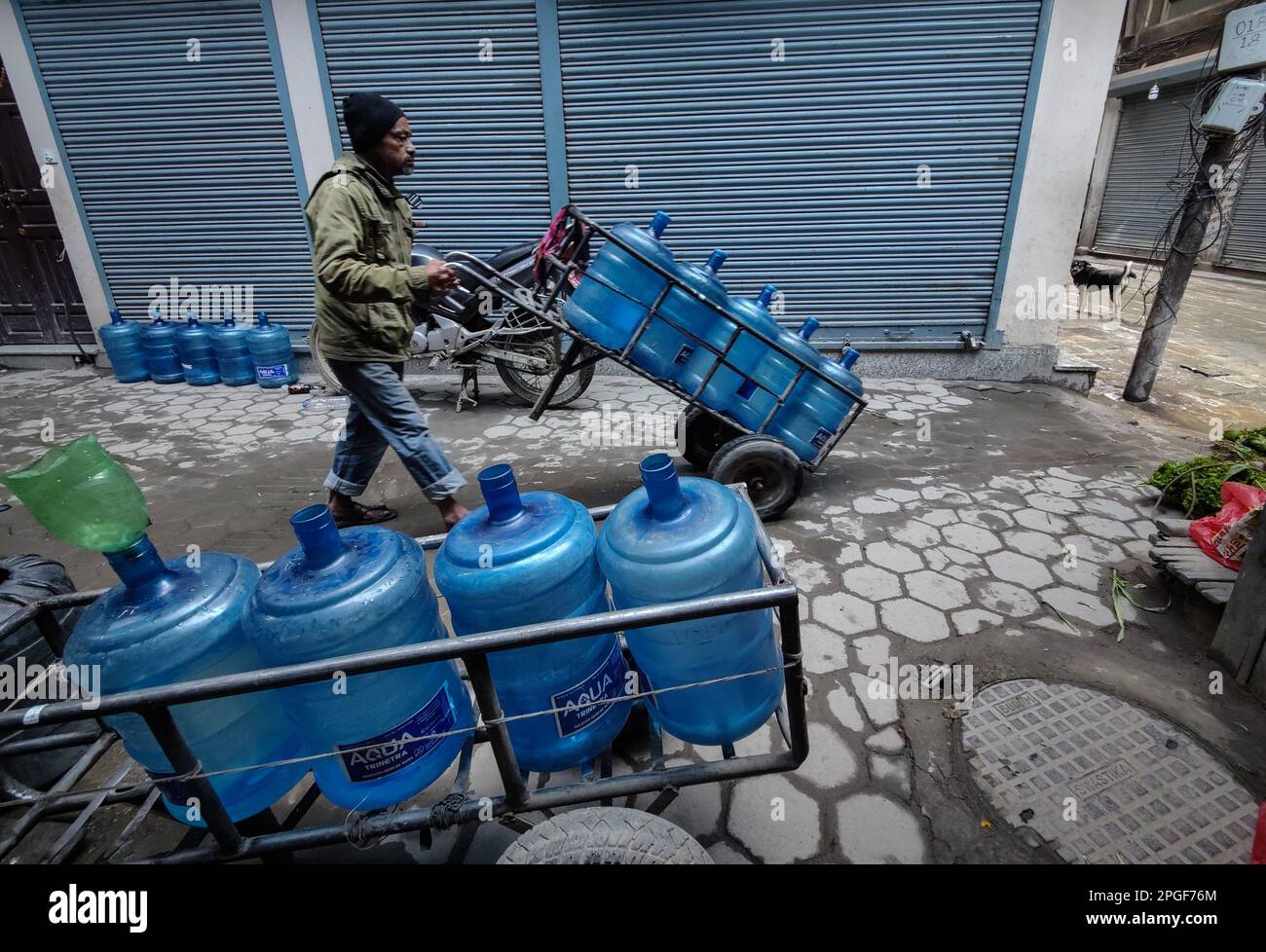 Kathmandu, Bagmati, Nepal. 22nd Mar, 2023. A man carries water jars for ...