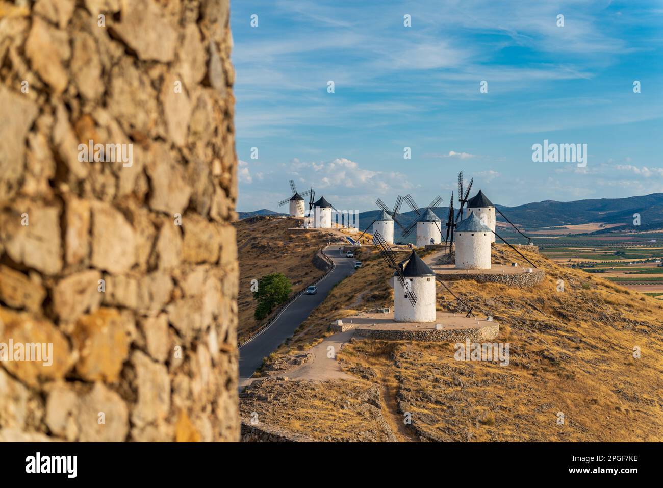 Consuegra vintage windmill array and stone wall Stock Photo - Alamy