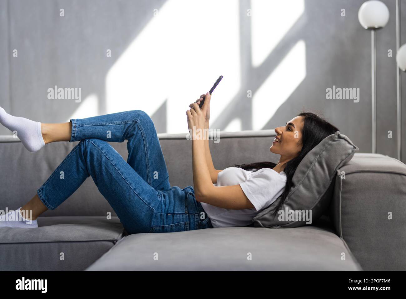 Portrait beautiful woman use smart mobile phone on sofa in living room ...
