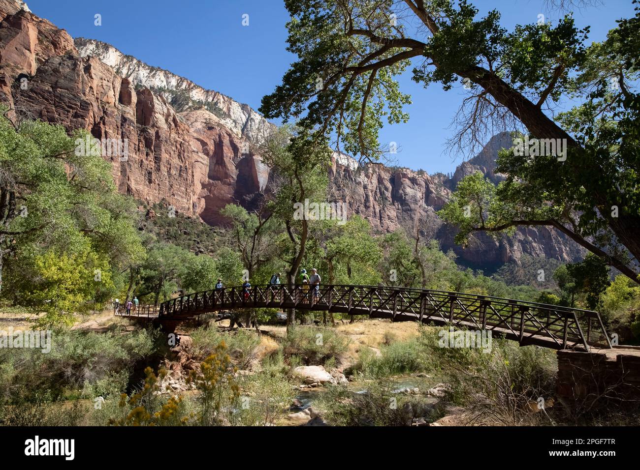 Hikers crossing bridge in Zion National Park over the Virgin River ...