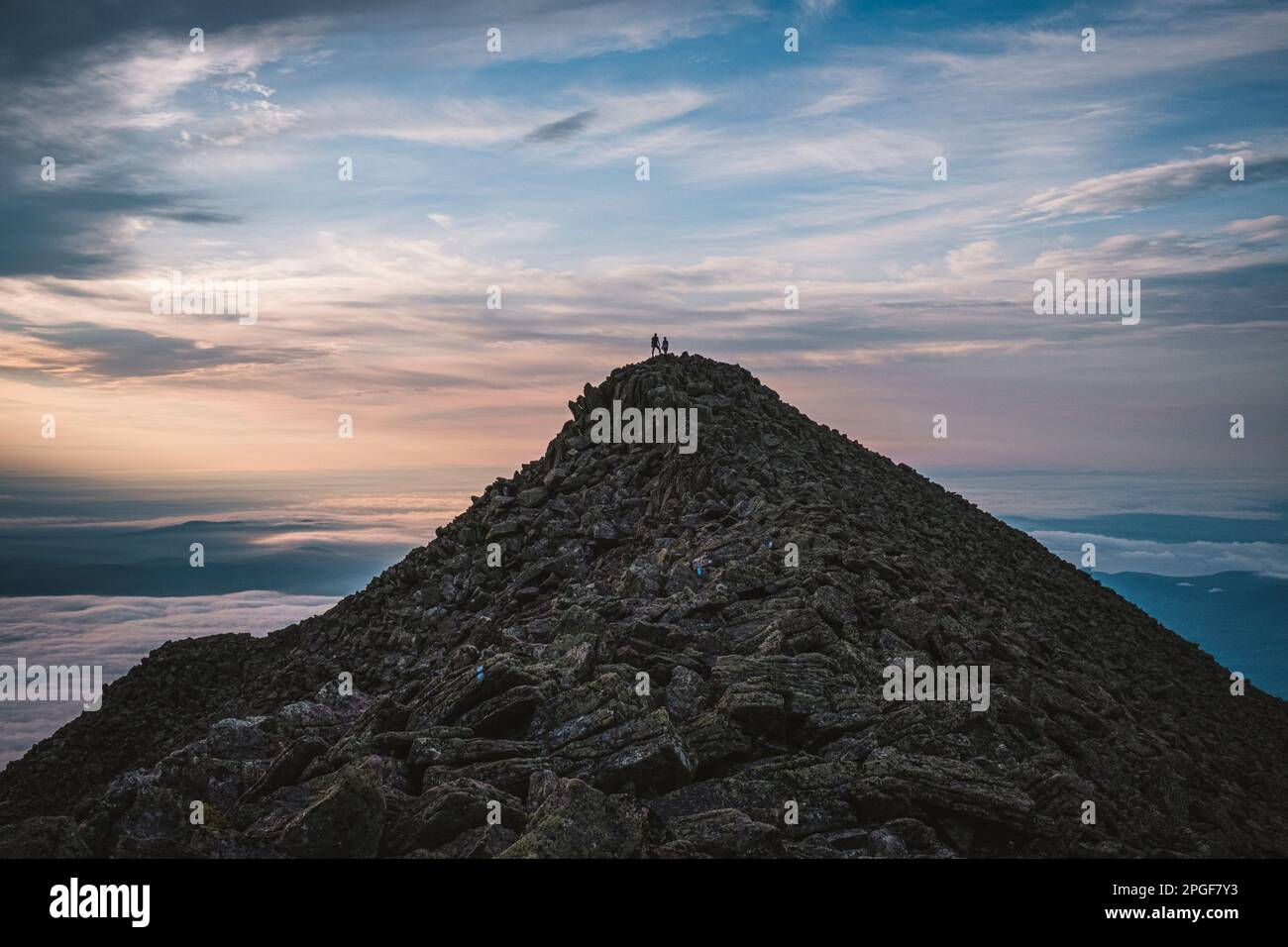 two tiny figures stand on summit of Mount Katahdin, Maine, sunrise ...