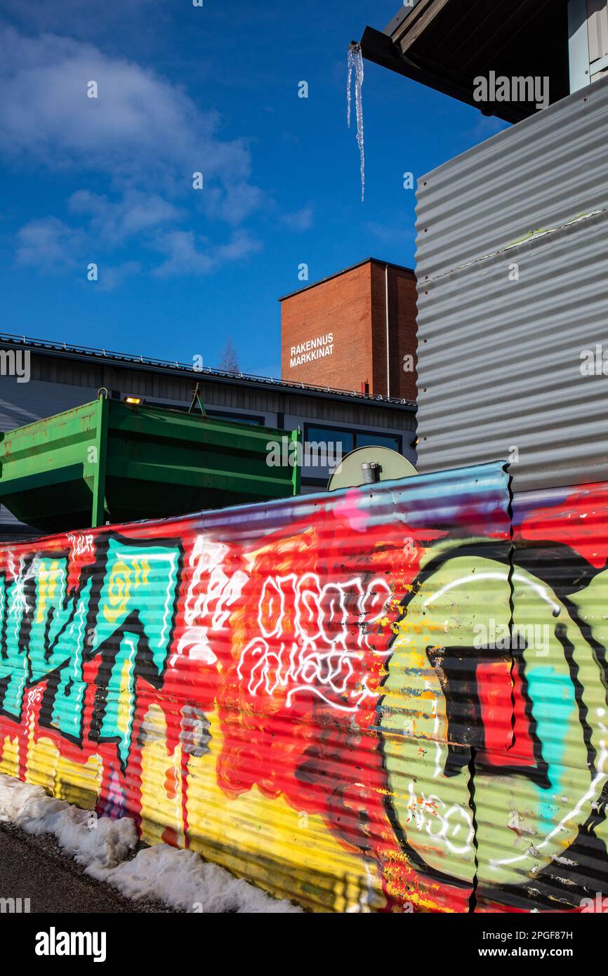 Colorful graffiti covered corrugated iron fence in Kyläsaari industrial ...