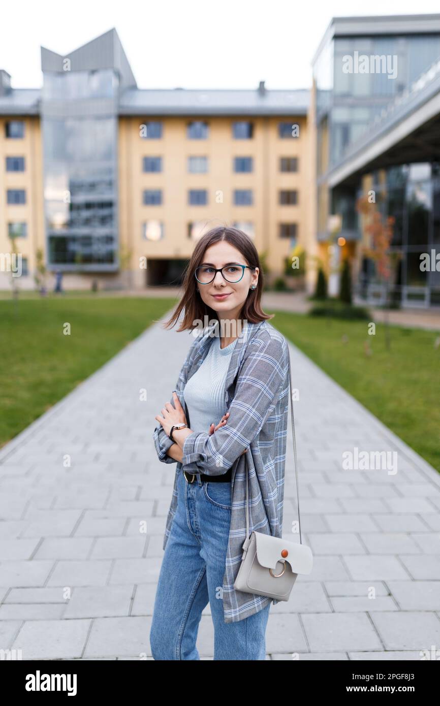 young female student in a jacket and jeans on campus Stock Photo - Alamy