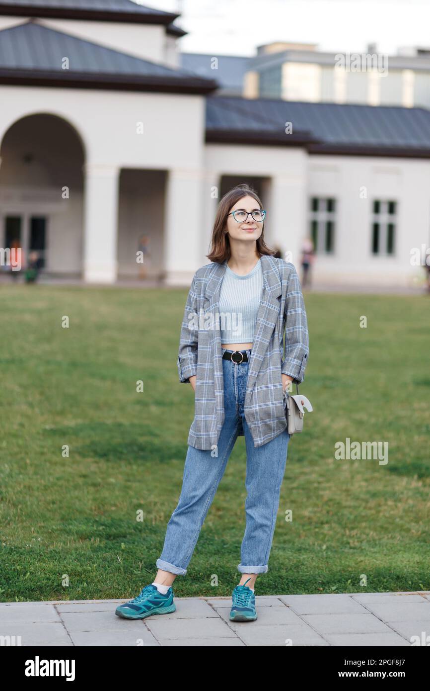 young female student in a jacket and jeans on campus Stock Photo - Alamy
