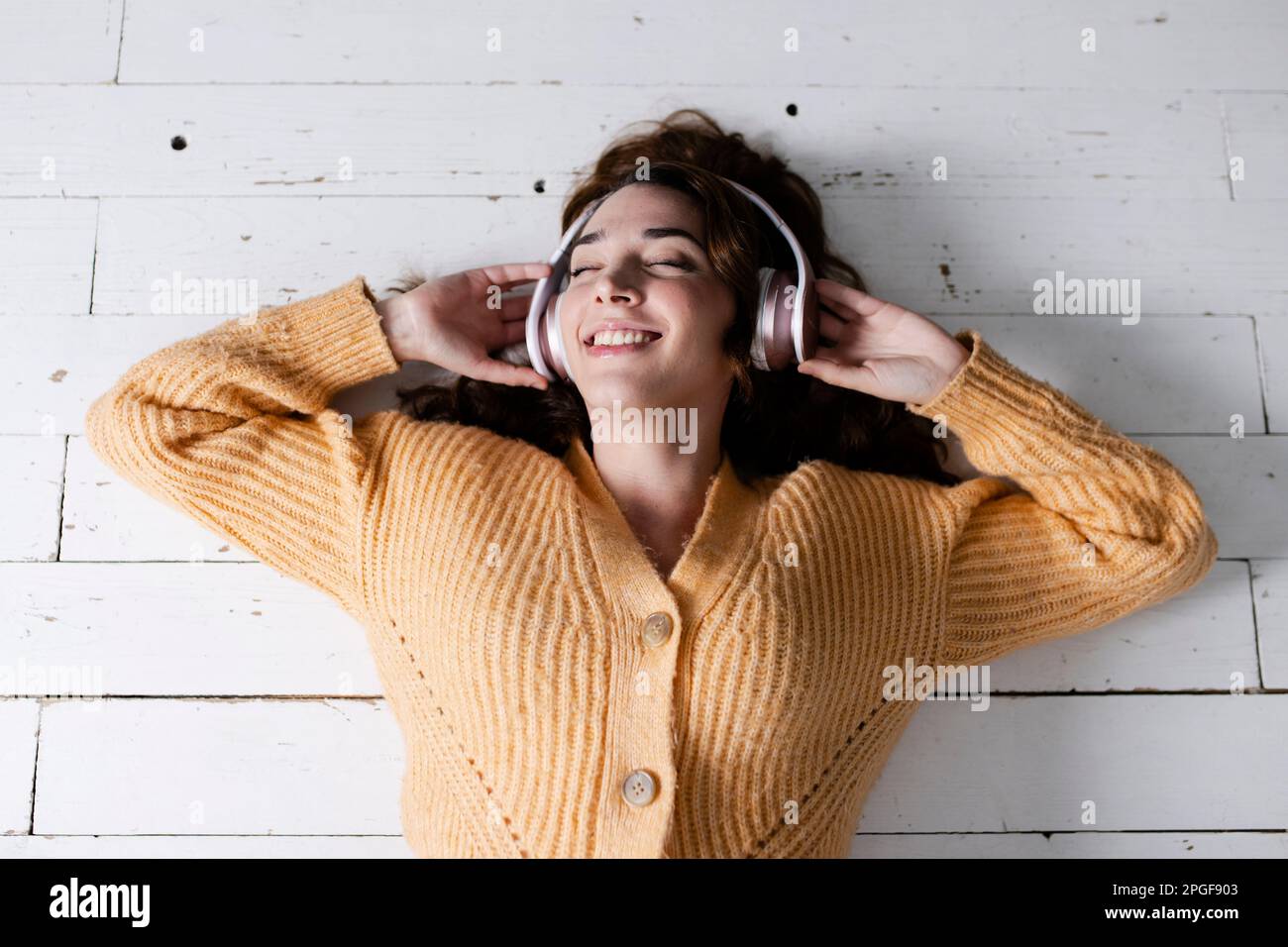 relaxed woman lying on the floor listen to music with headphones Stock ...