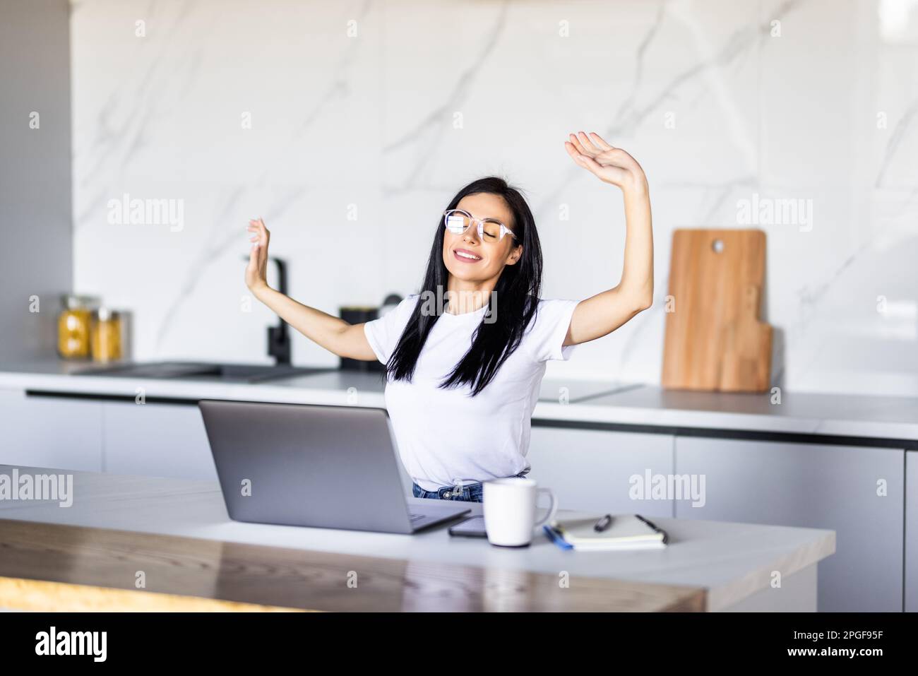 Young woman exulting using calculator and laptop for calculating ...