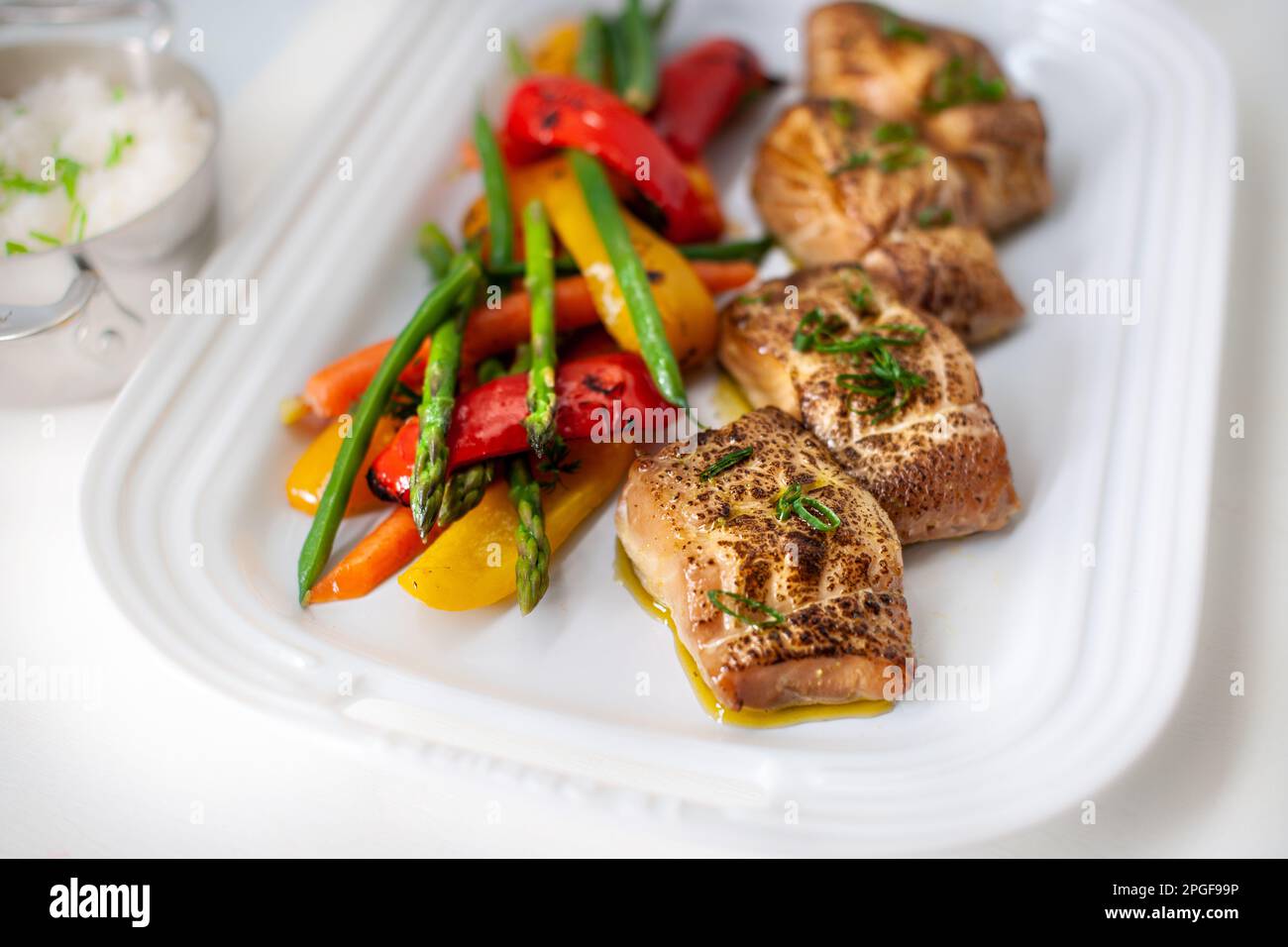 Black Cod on serving platter with grilled vegetables and rice Stock ...