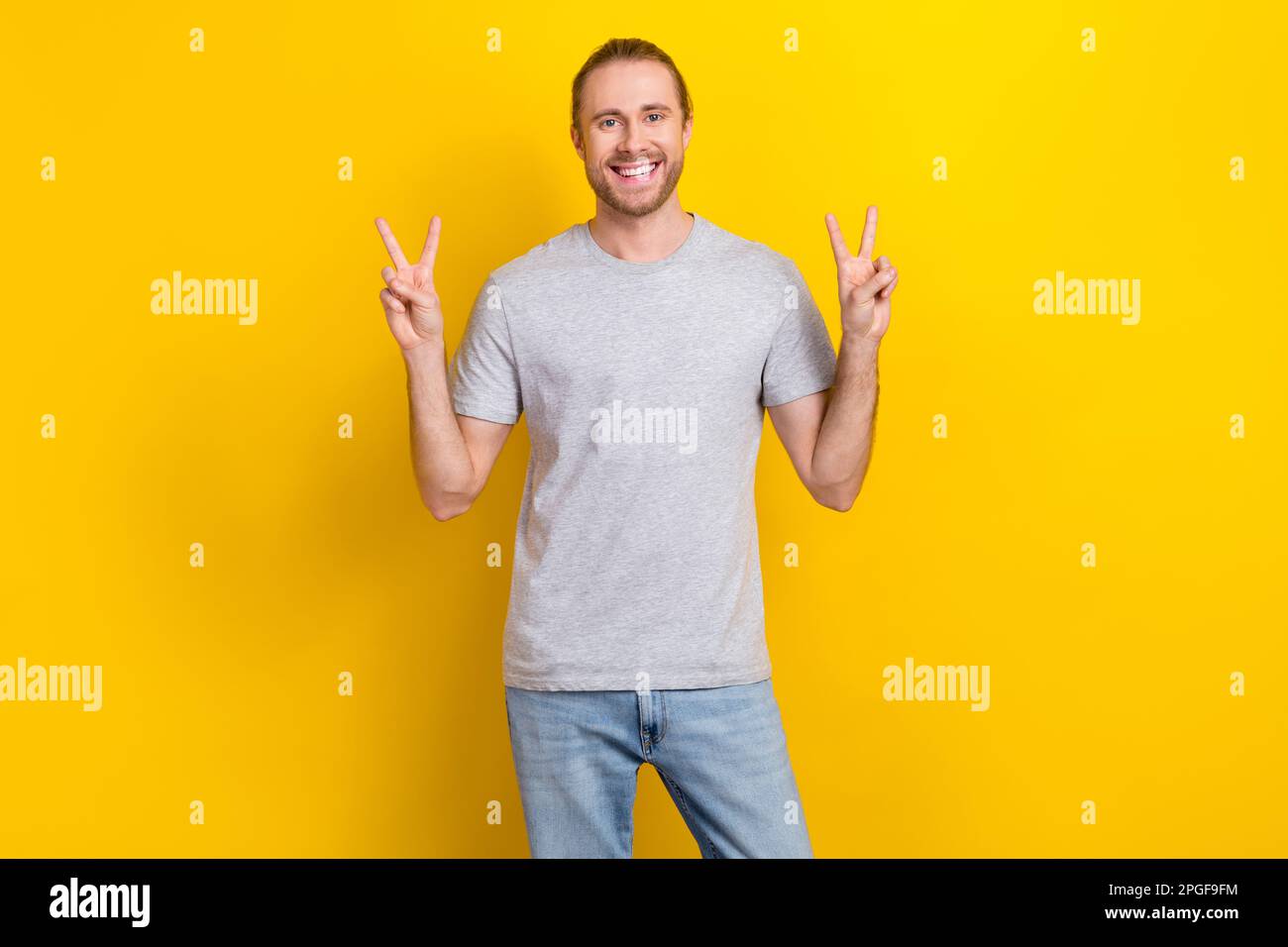 Photo of positive funny guy dressed grey t-shirt smiling showing two v ...