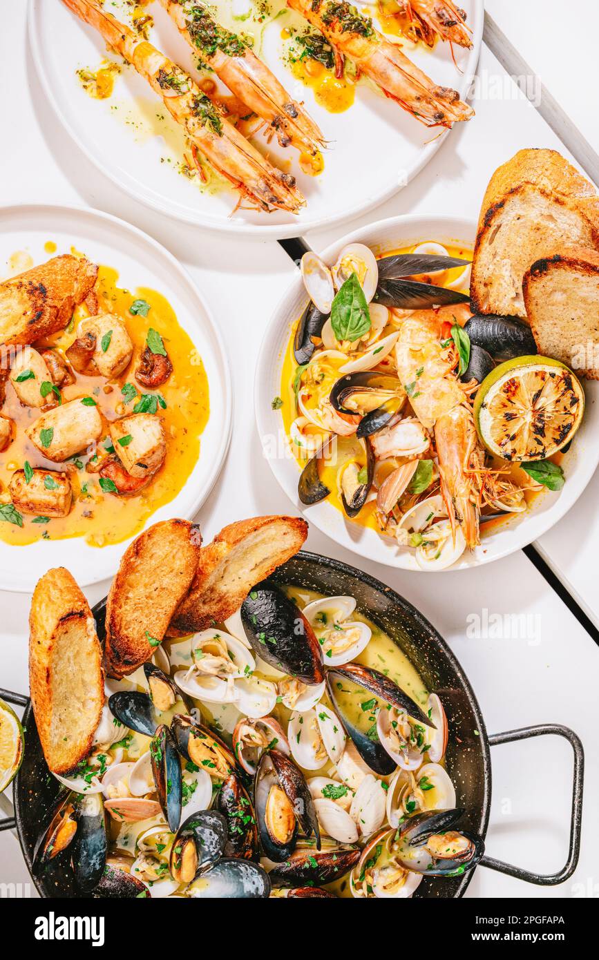 four different seafood dishes in the table Stock Photo - Alamy